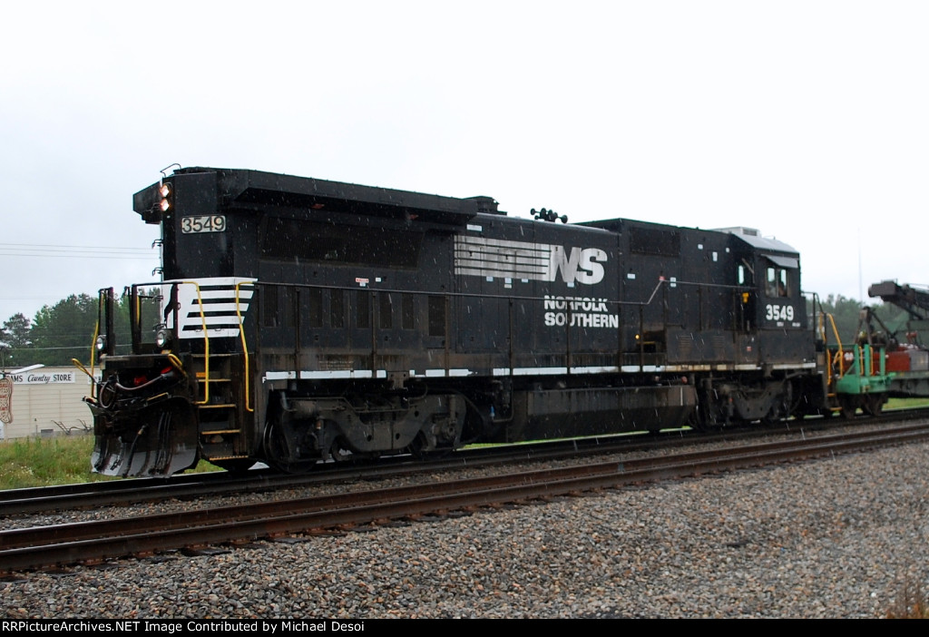 NS B32-8 # 3549 leads a westbound work train in the rain about to cross @hinquapin Rd.
